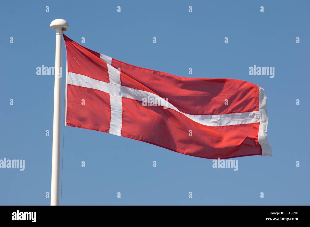 Swiss banner flag flying - white cross on red background - blue sky ...