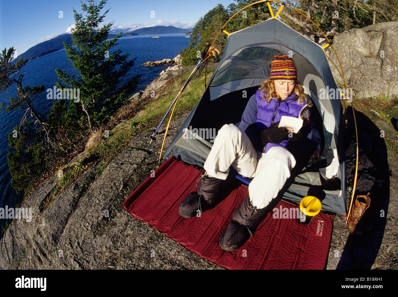Woman reads a book in her tent, Lighthouse Park, West Vancouver ...