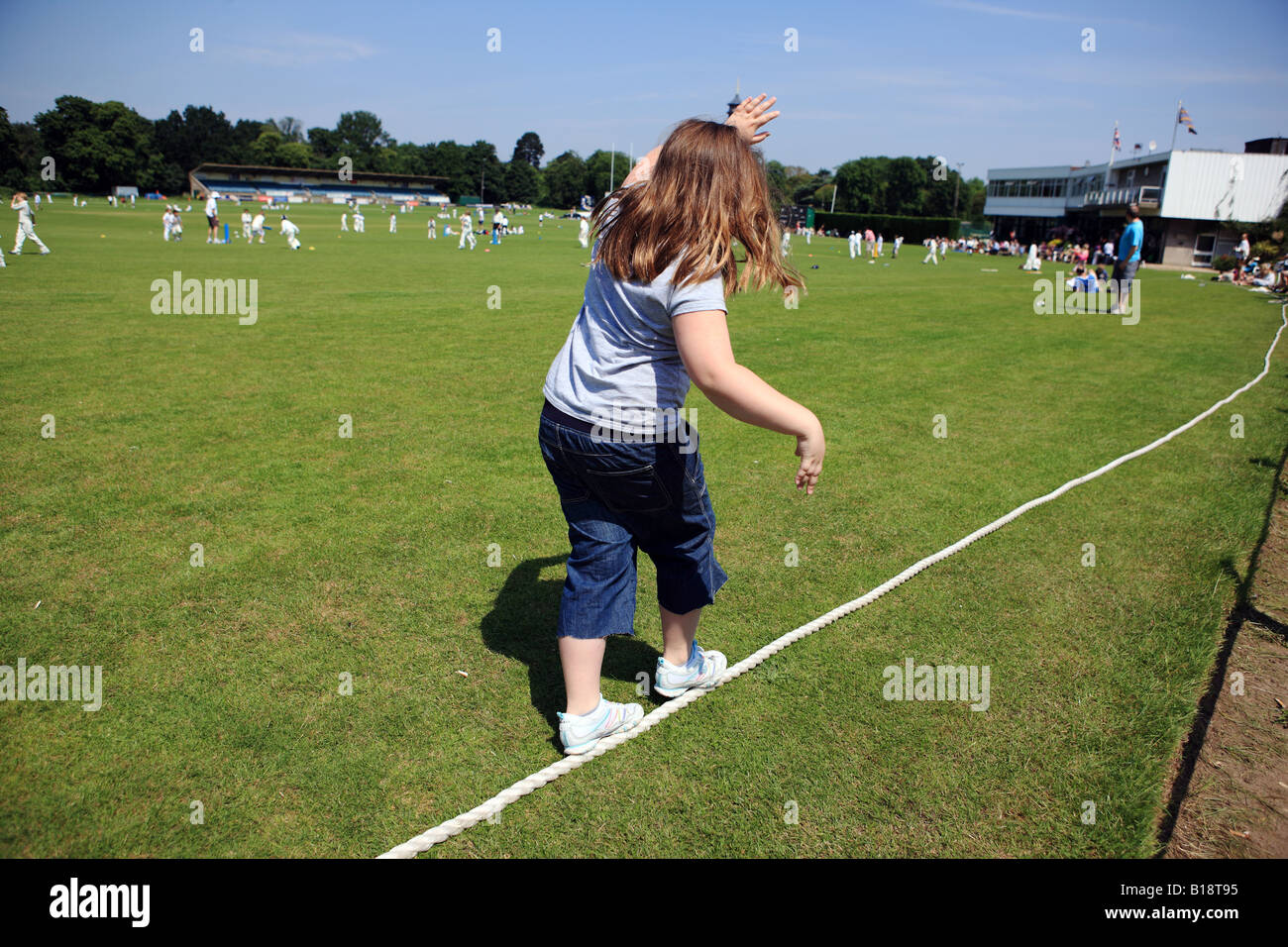 Young girl playing at walking a tight rope Stock Photo - Alamy