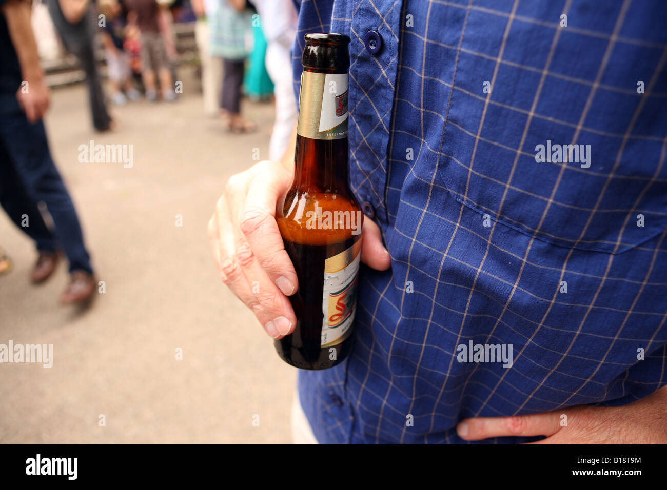 Gentleman holding a bottle of lager, after work Stock Photo - Alamy