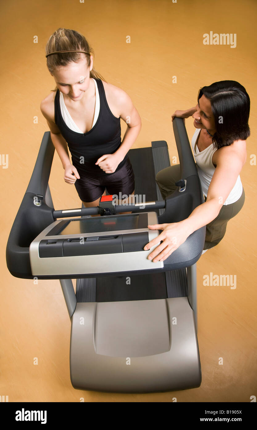 Woman running on the treadmill with other woman watching Stock Photo ...