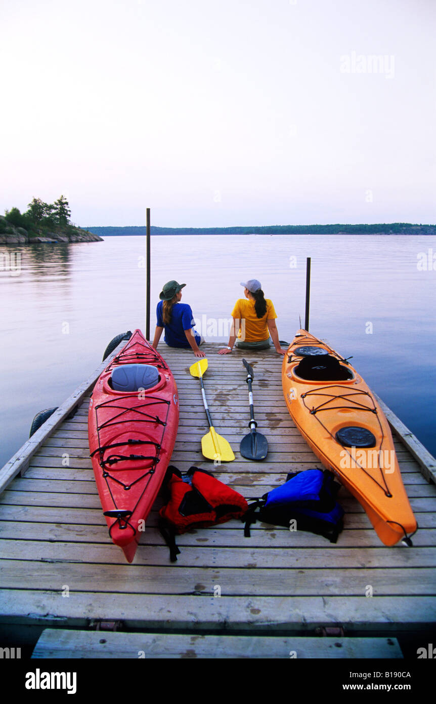 Kayakers relaxing on Nutimik Lake campground boat dock, Whiteshell ...