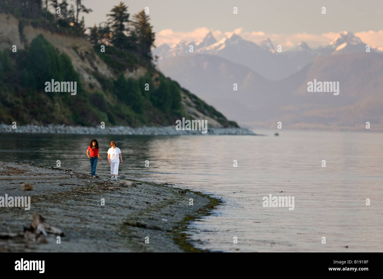 Two ladies strolling along the beach in the evening at Goose Spit, in ...