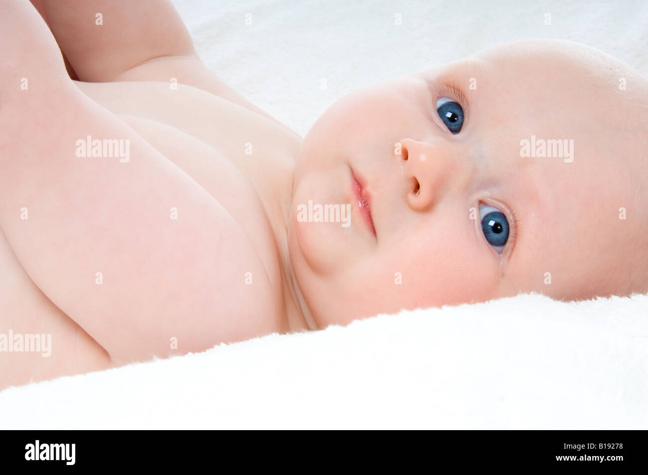 Closeup of a caucasian baby with blue eyes laid on its back Stock Photo ...