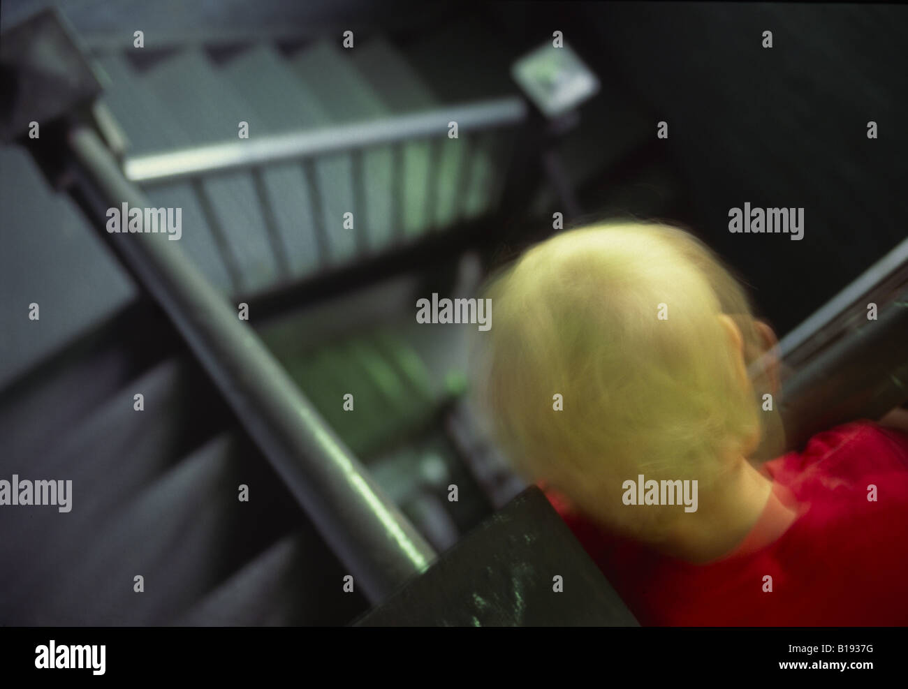 young boy looking over stair rail Stock Photo - Alamy