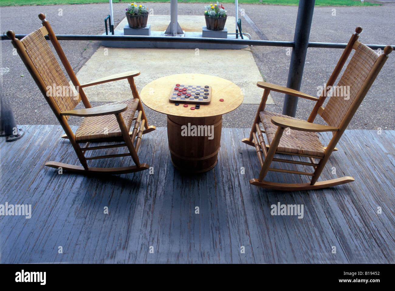 Two rocking chairs and a chess board are outside a general store in ...