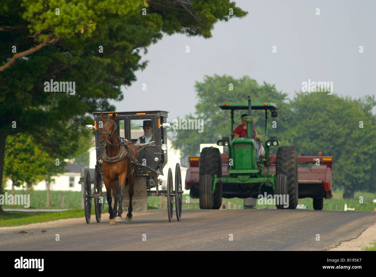ILLINOIS Arcola Amish buggy and tractor on road pulled by horse Stock ...