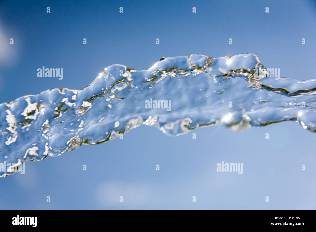 Jet of water frozen against a bright blue sky Stock Photo - Alamy