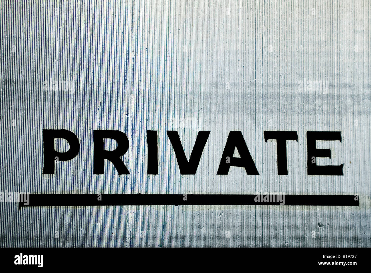 Private sign written with black paint on a textured glass window in a ...