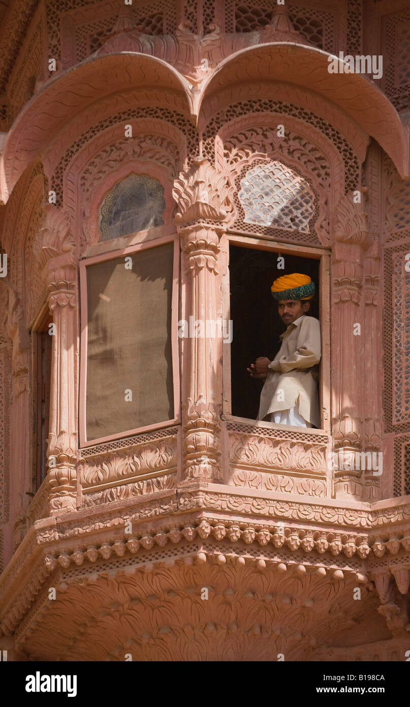A Rajasthani man looks out a stone carved window at the MEHERANGARH ...