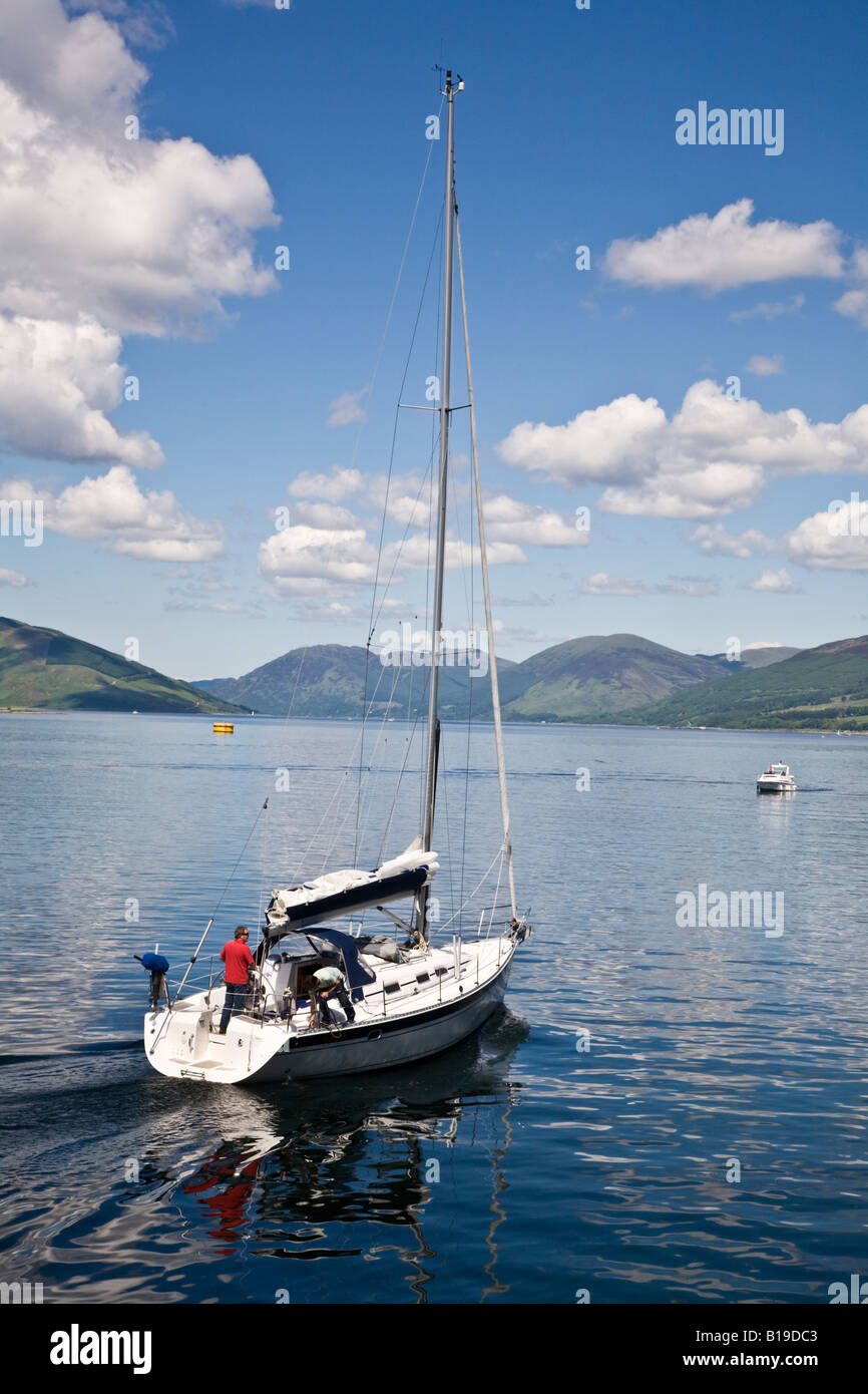 A yacht sailing under power out into Rothesay Bay, Isle of Bute, Argyll ...