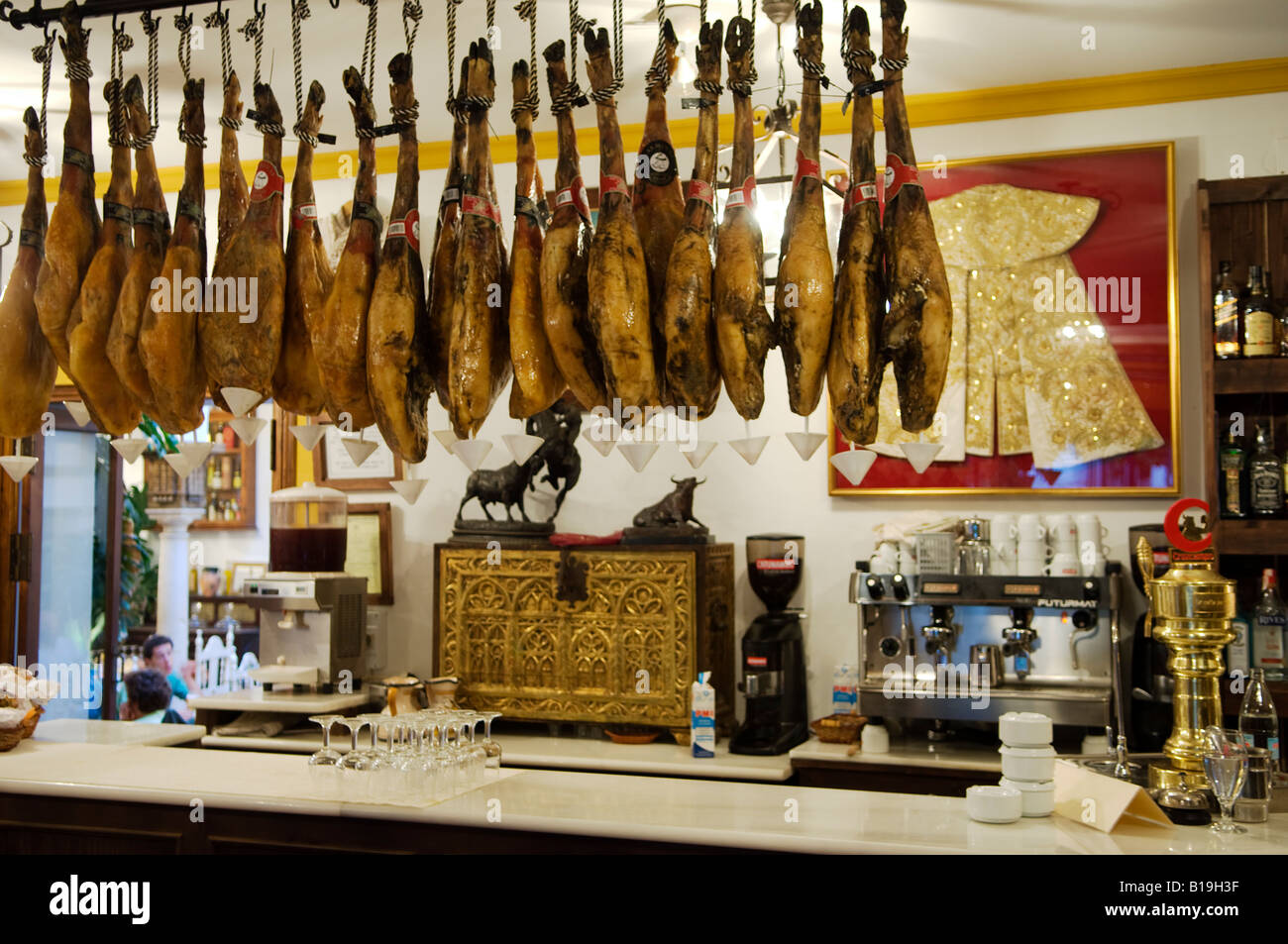 Spain, Andalucia, Seville. Iberian Hams hang up at a bar in the Barrio ...