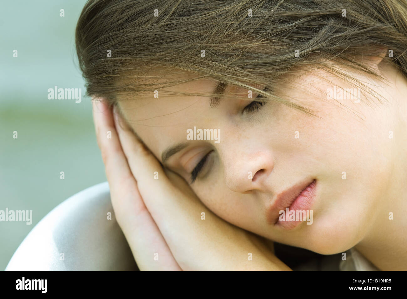 Teenage girl resting head on hands, close-up Stock Photo - Alamy