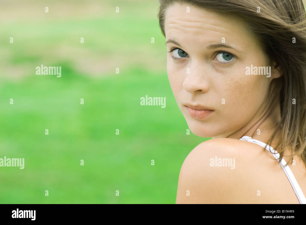 Teen girl looking over shoulder at camera, close-up Stock Photo - Alamy