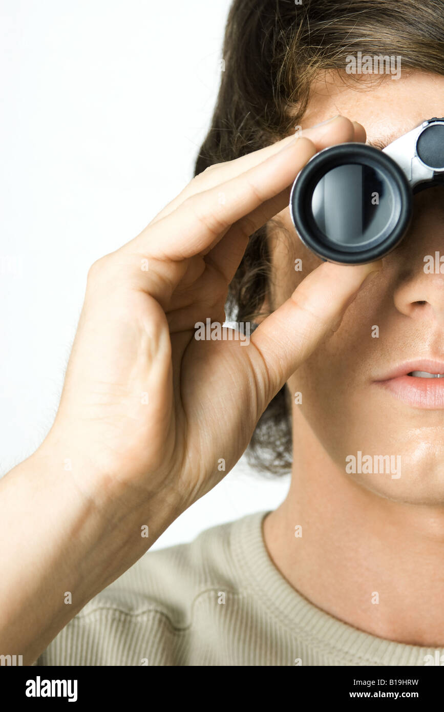 Young man looking through binoculars, close-up, cropped Stock Photo - Alamy