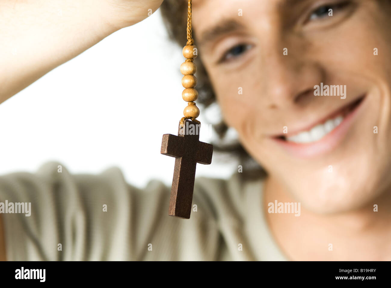 Young man looking at cross, smiling, close-up Stock Photo - Alamy