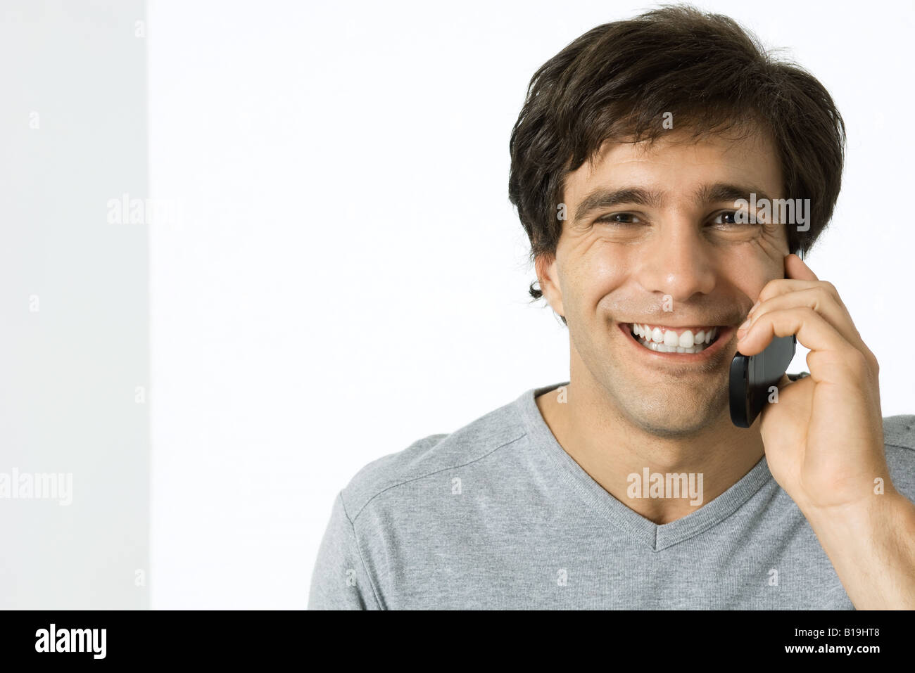 Man using cell phone, smiling at camera Stock Photo - Alamy