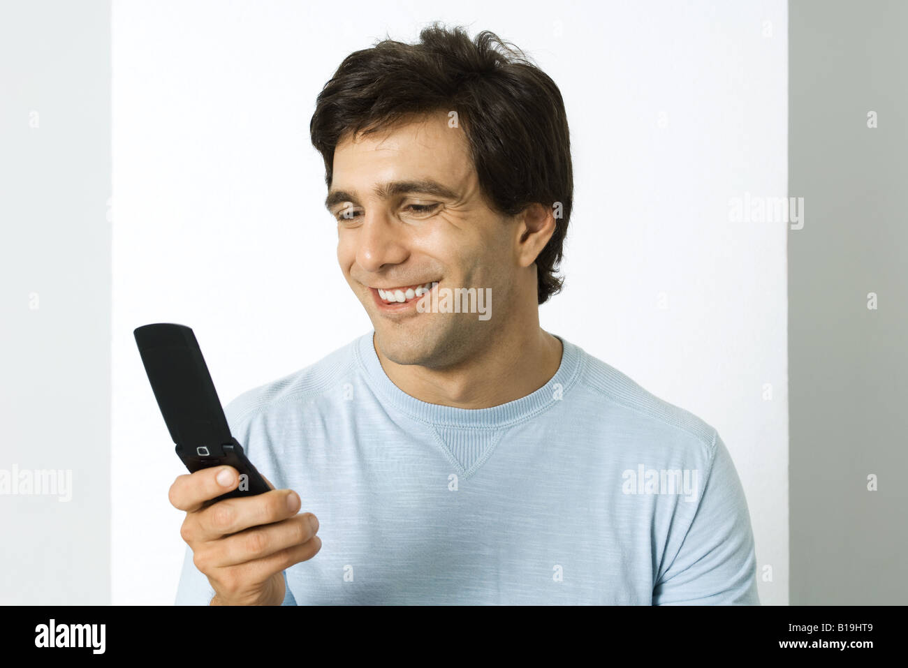 Man looking at cell phone, smiling Stock Photo - Alamy