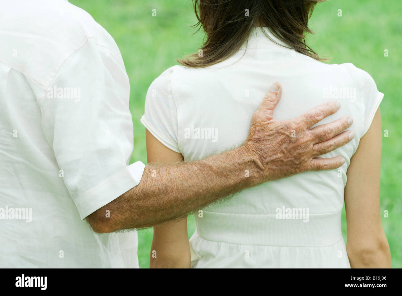 Senior man with hand on teen girl's back, rear view, cropped Stock ...