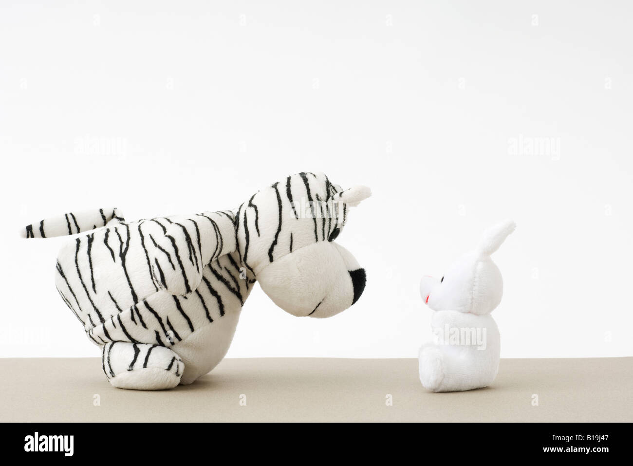 Toy tiger facing toy rabbit, close-up Stock Photo - Alamy