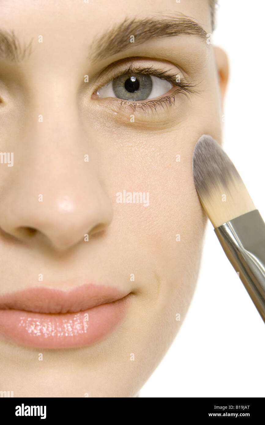 Woman applying make-up to cheek, smiling at camera, close-up Stock ...