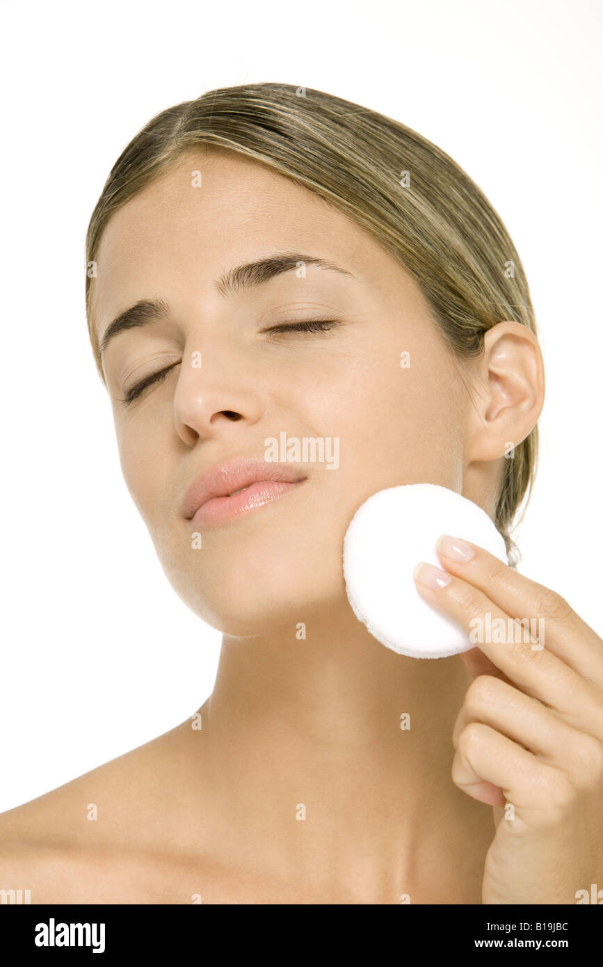 Woman using powder puff on cheek, eyes closed Stock Photo - Alamy