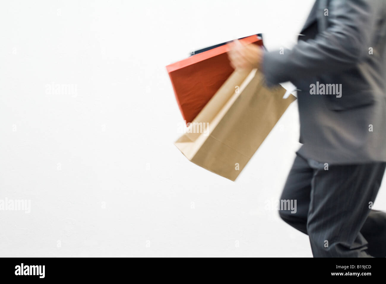 Man running with shopping bags, cropped view Stock Photo - Alamy