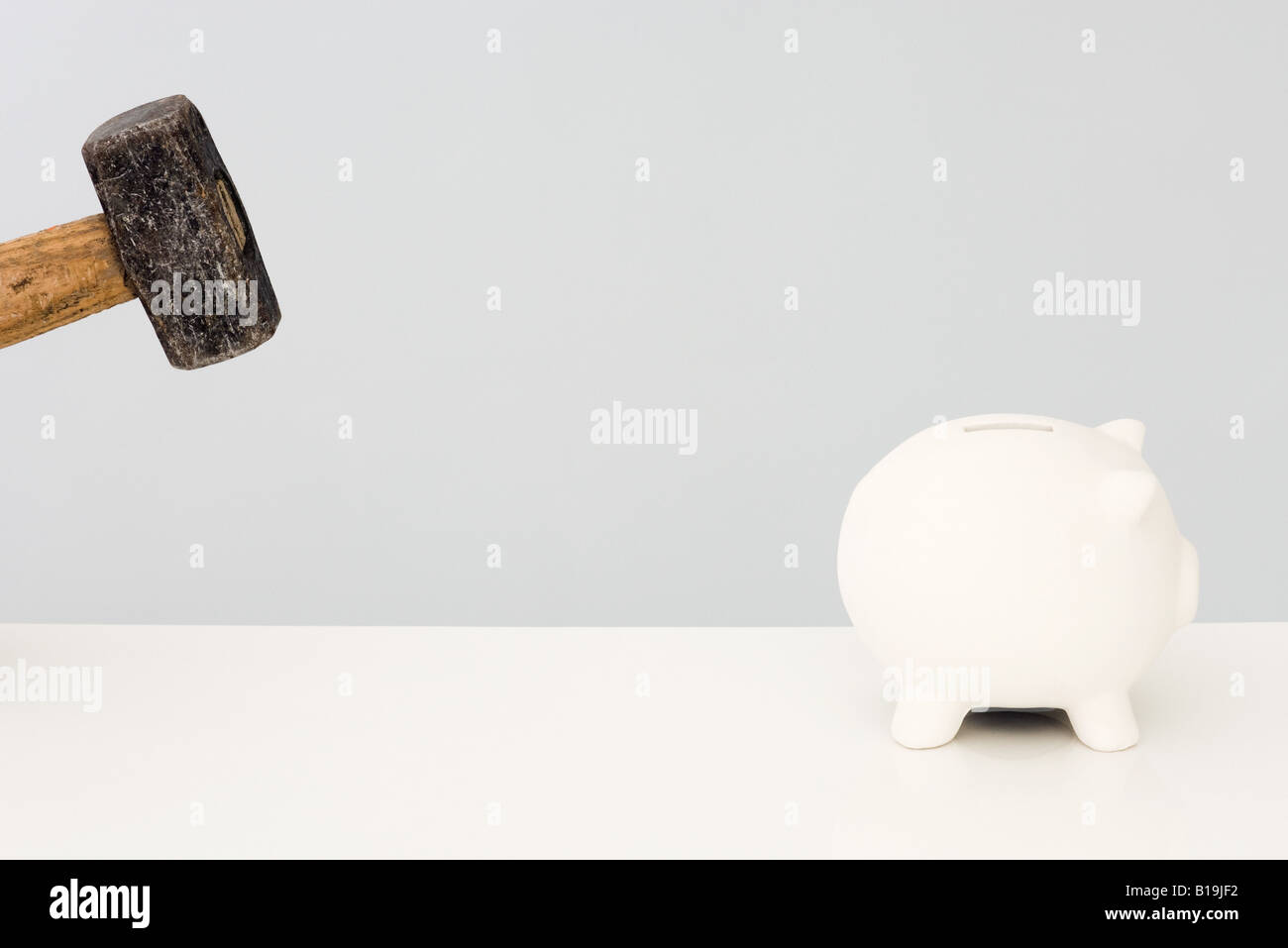 Piggy bank running away from hammer Stock Photo - Alamy