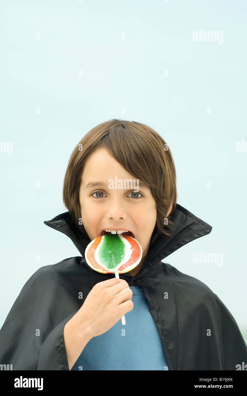 Boy wearing vampire cape, eating large lollipop, portrait Stock Photo ...