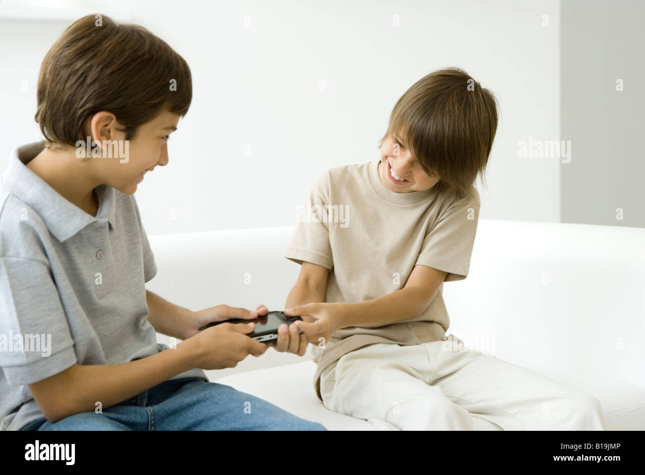 Two brothers fighting over handheld video game Stock Photo - Alamy