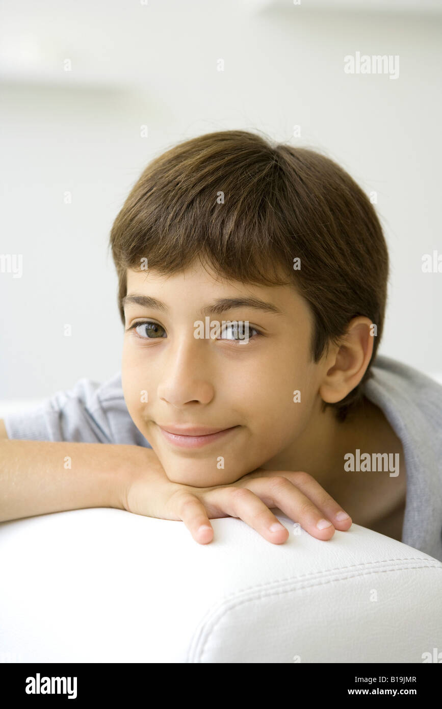 Boy resting head on chin, smiling at camera, portrait Stock Photo - Alamy