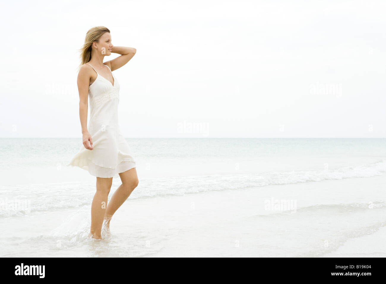Woman in sundress walking at the beach, side view Stock Photo - Alamy