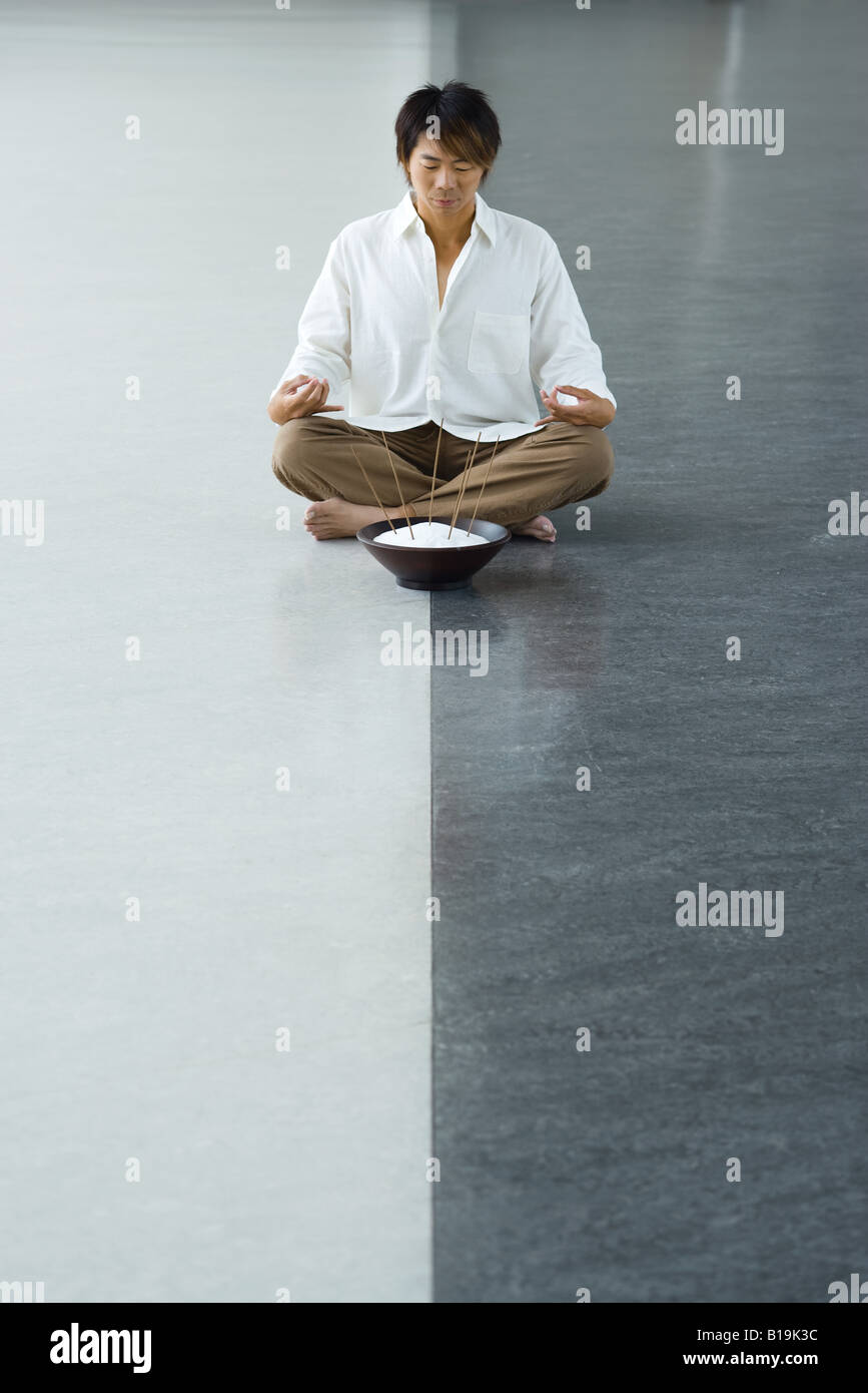 Man sitting in lotus position with bowl of incense Stock Photo - Alamy