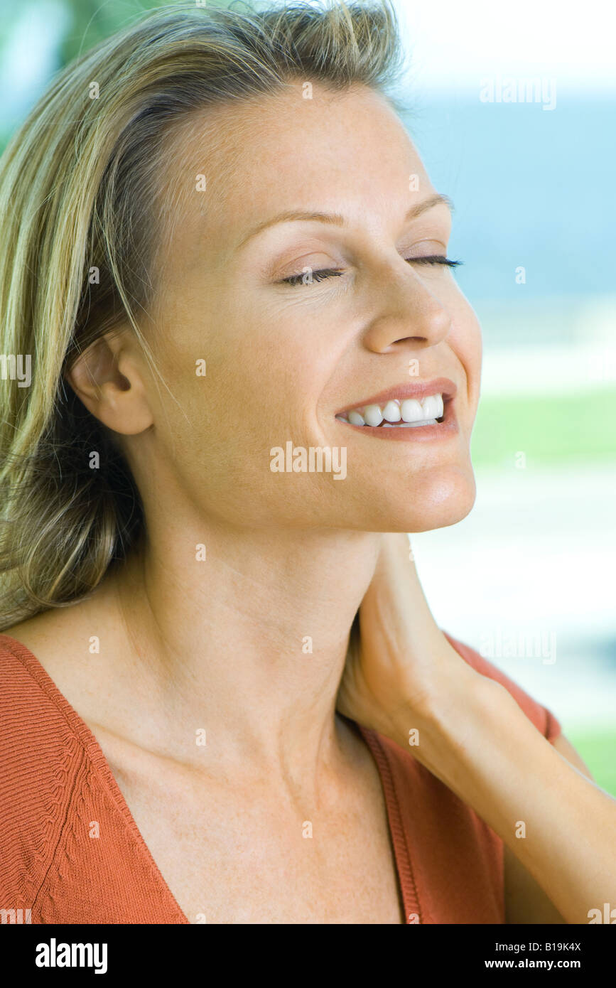 Woman smiling, holding neck, eyes closed Stock Photo - Alamy