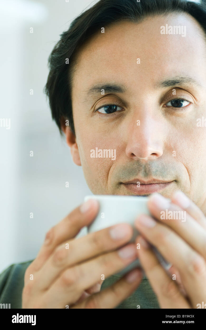 Man holding cup, looking at camera, portrait Stock Photo - Alamy