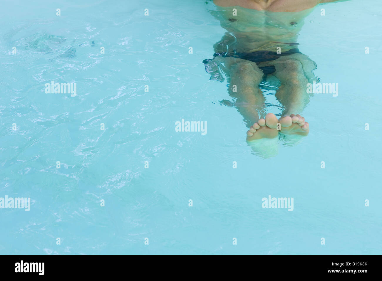 Man floating in swimming pool, cropped view Stock Photo - Alamy