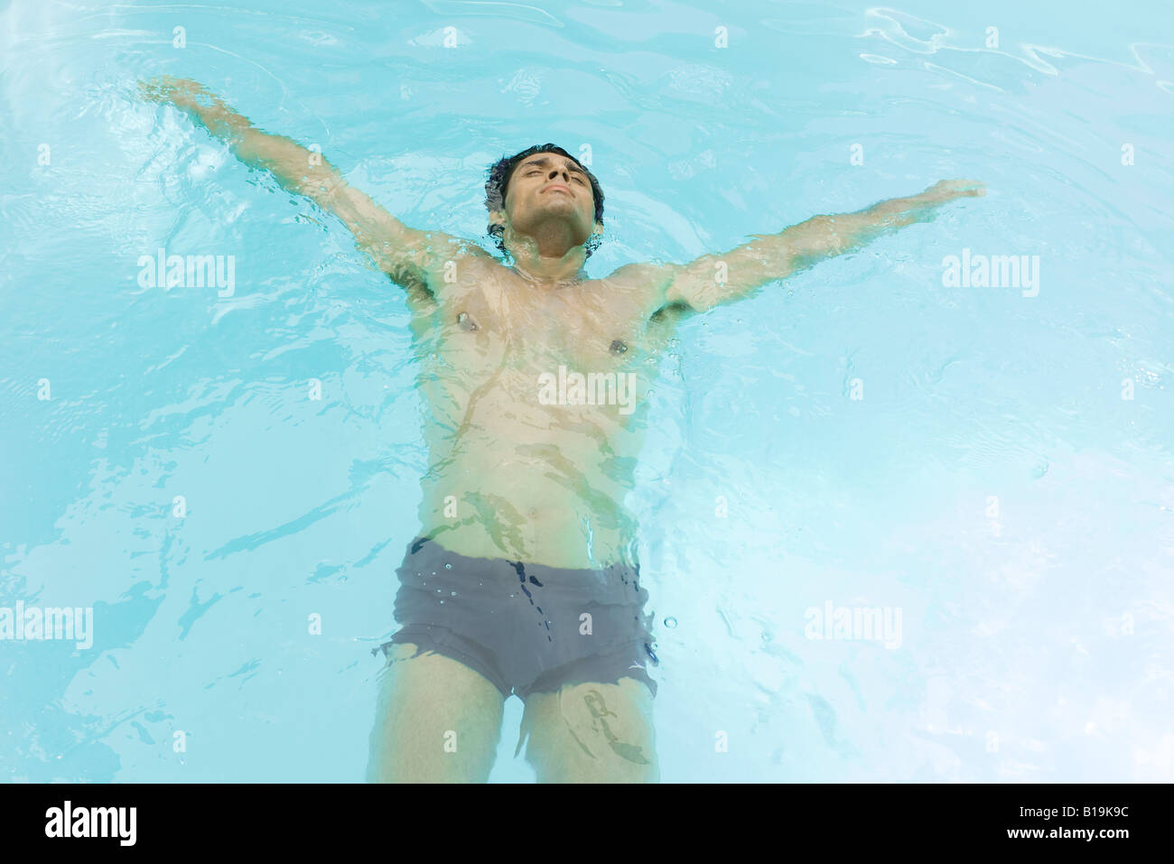Man floating on back in swimming pool Stock Photo - Alamy
