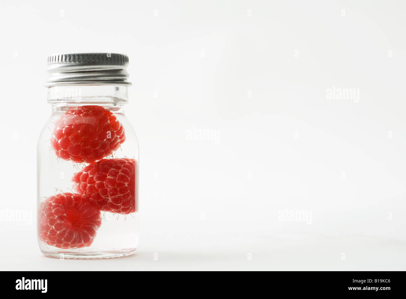 Raspberries in small jar Stock Photo - Alamy