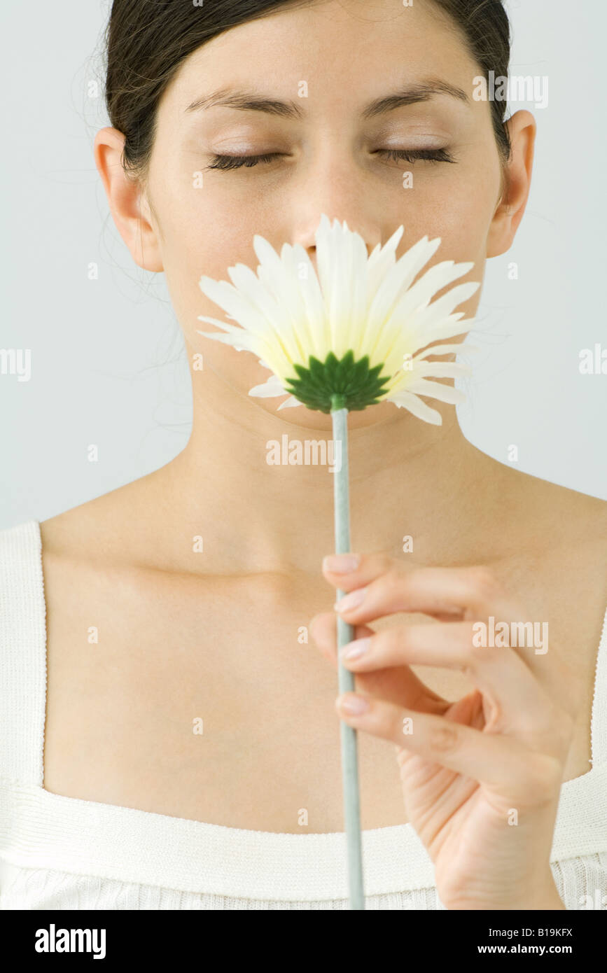 Young woman smelling flower, eyes closed, portrait Stock Photo - Alamy