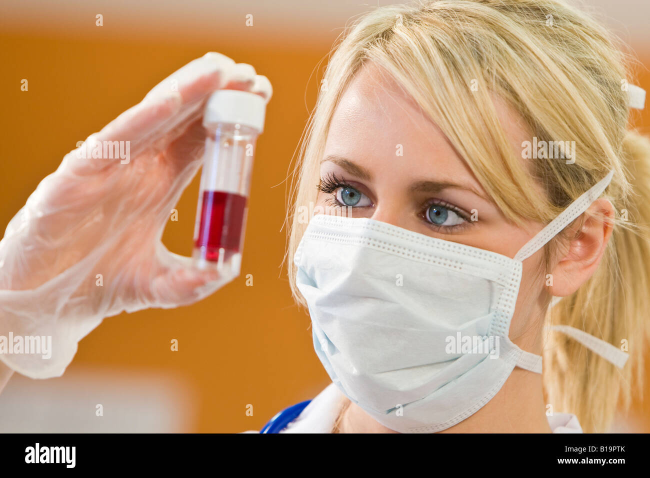 A young female doctor or nurse looking at a blood sample Stock Photo ...