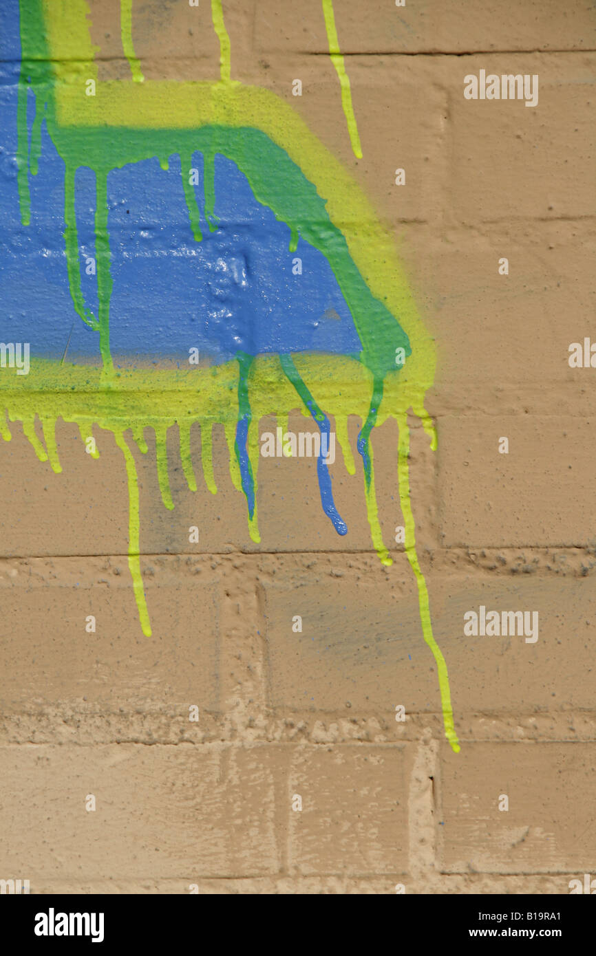 dripping yellow paint on graffiti design on wall Stock Photo - Alamy
