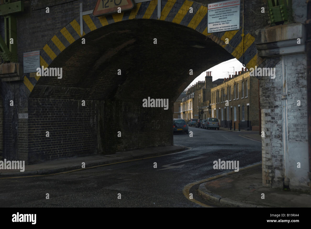 Road under railway arch with Victorian housing visible through it ...