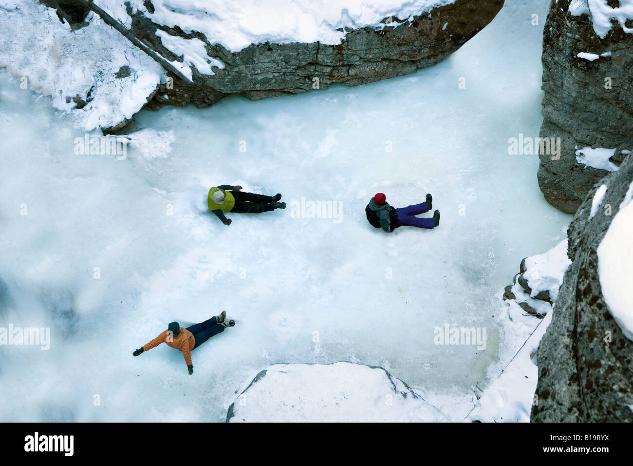 People sliding down ice in canyon Stock Photo - Alamy