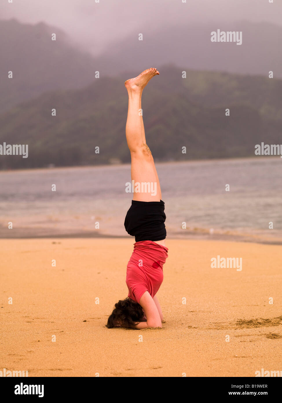 Woman doing headstand on beach hi-res stock photography and images - Alamy
