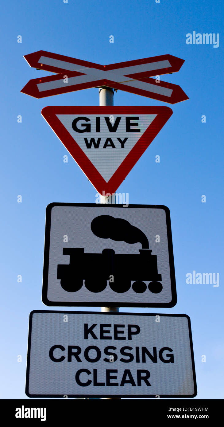 Steam train crossing road signs at Dunster Somerset England Stock Photo ...