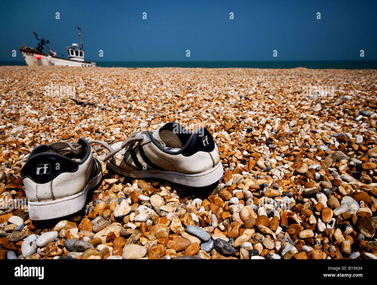 A pair of discarded trainers left on the beach at Dungeness in Kent ...