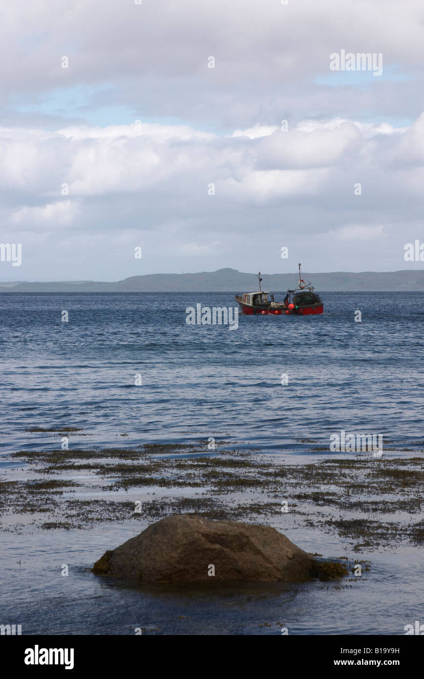 Fishing boat leaving sannox on the isle of arran, travelling out across ...
