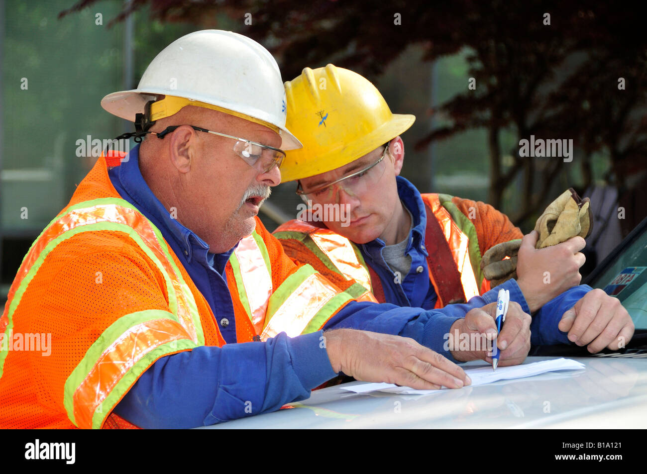 Engineers study blue print plans for building construction Stock Photo ...