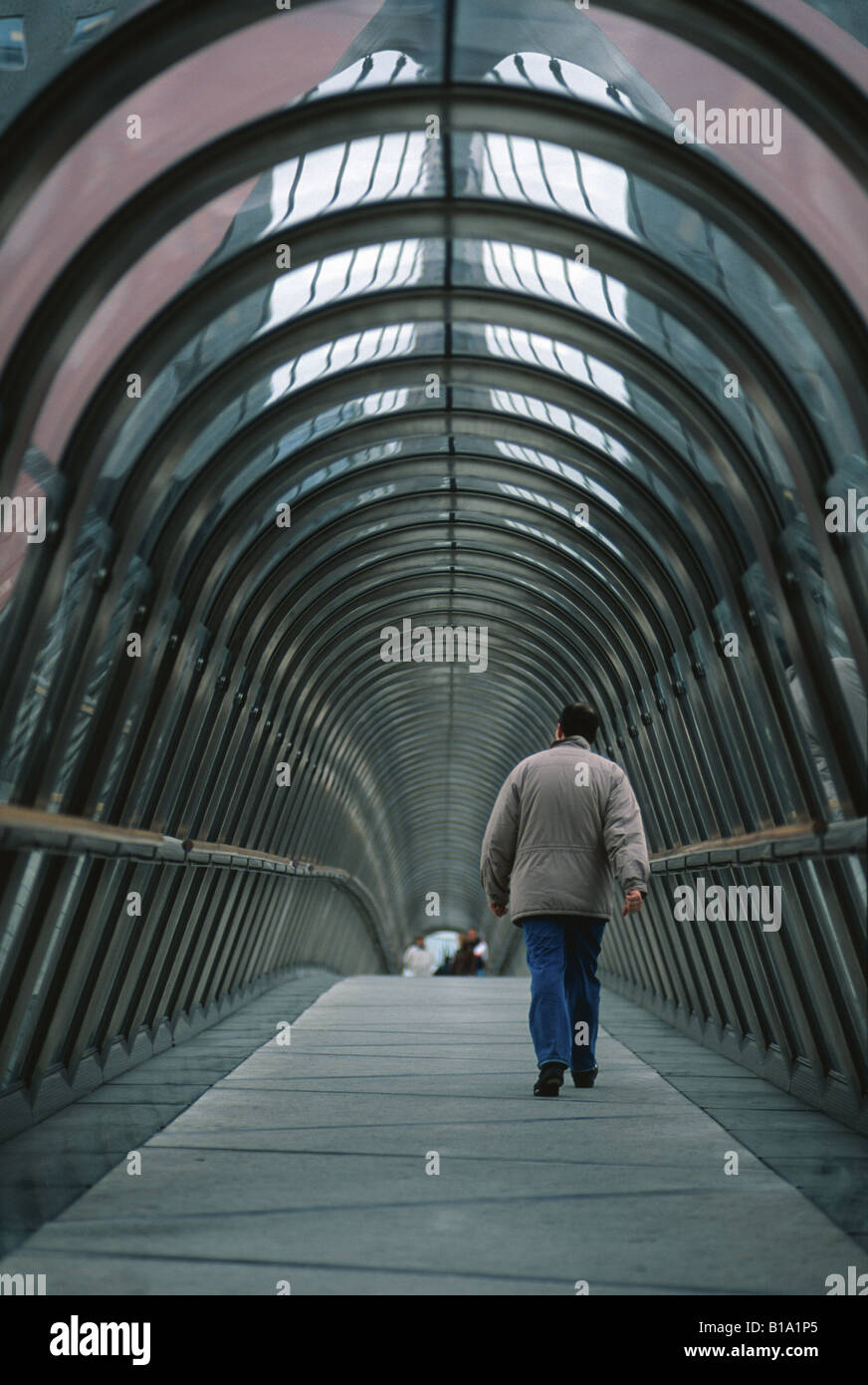 A man walks alone through the tunnel of a covered skybridge in La ...