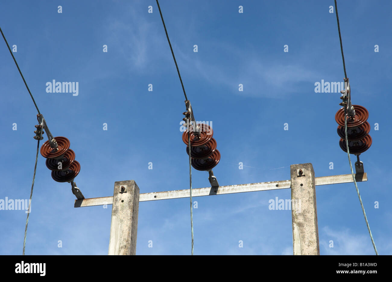 Three phase electricity power lines with insulators attached to pole ...